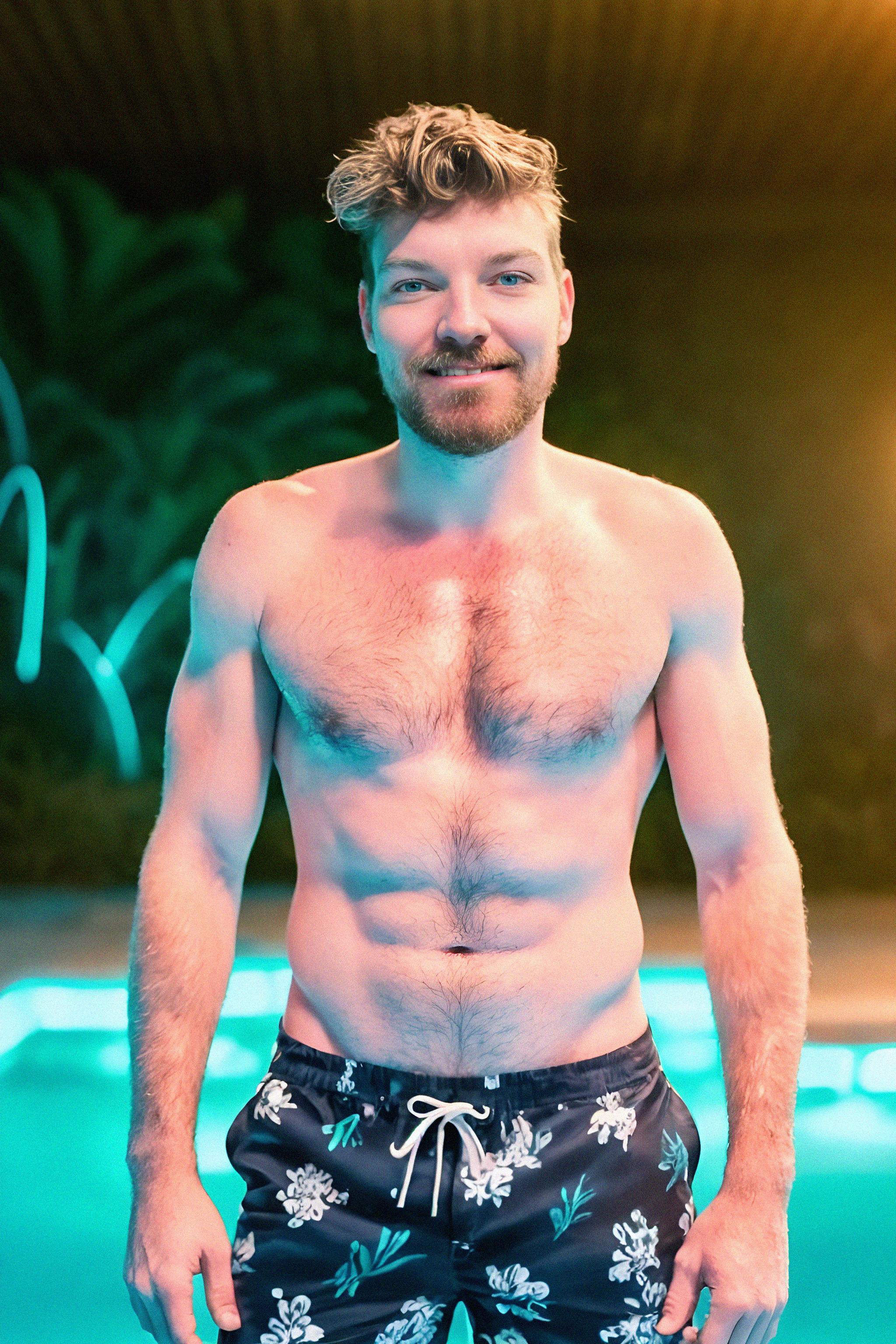 Smiling man , fit body in floral silk swim shorts and shirtless at pool ...